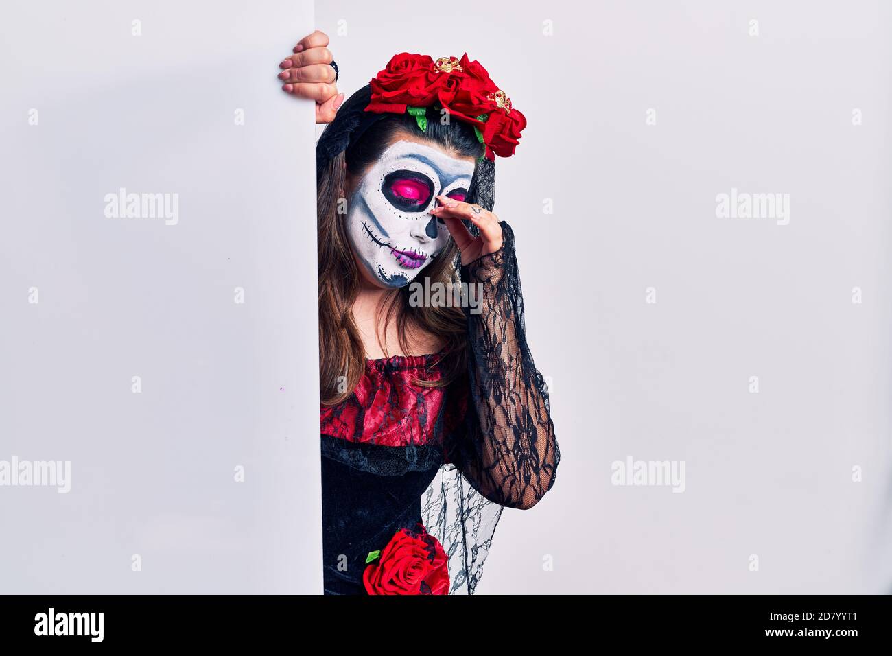 Young woman wearing day of the dead custome holding blank empty banner ...