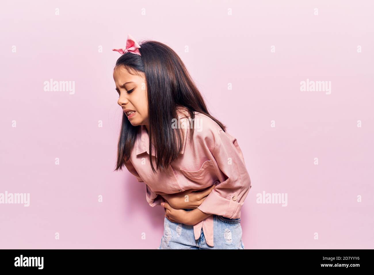 Beautiful child girl wearing casual clothes with hand on stomach ...