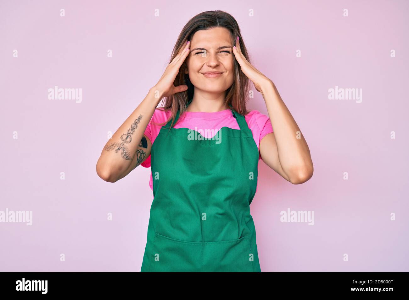 Beautiful caucasian woman wearing professional apron suffering from ...