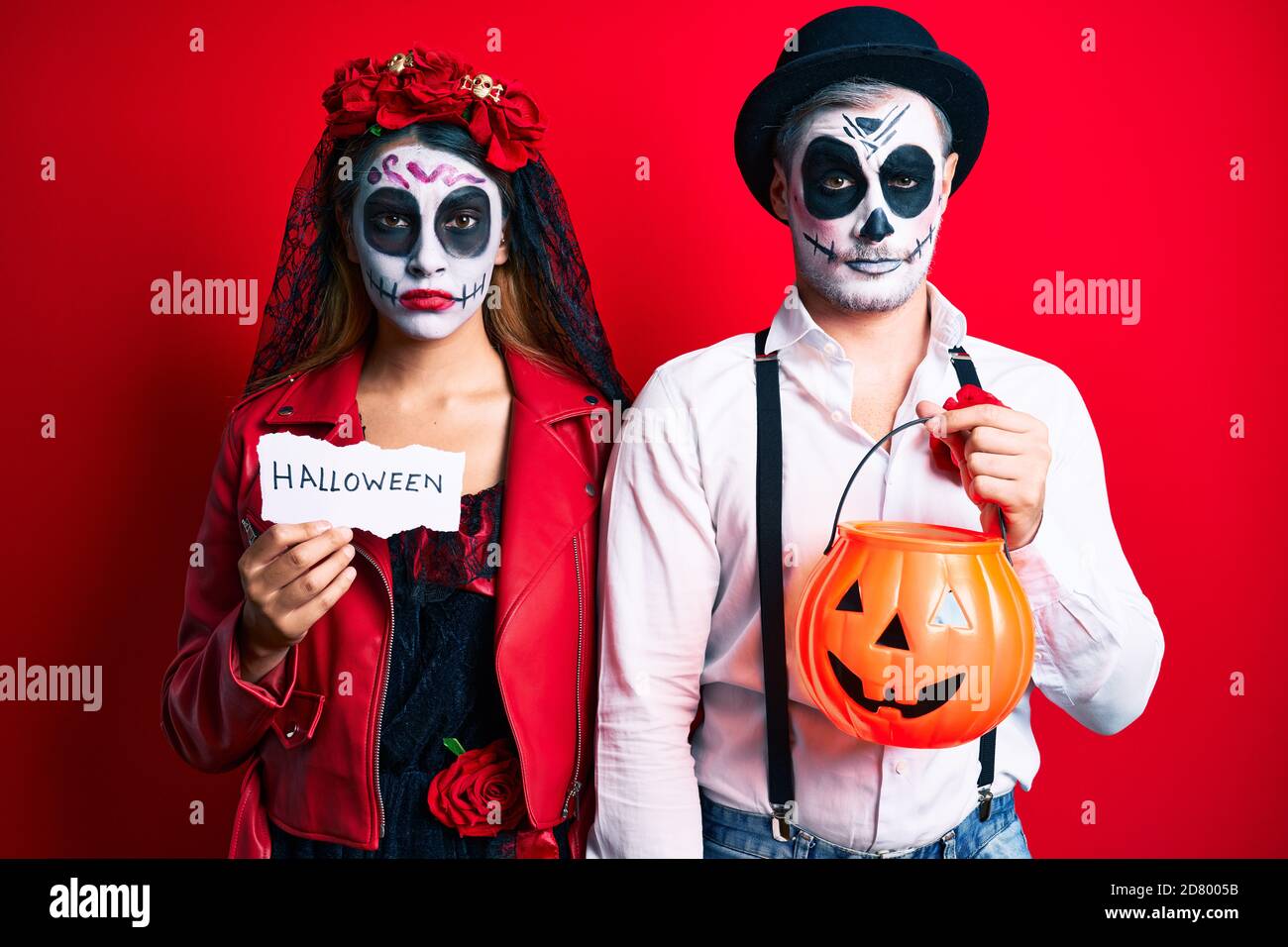 Couple wearing day of the dead costume holding pumpking and halloween ...