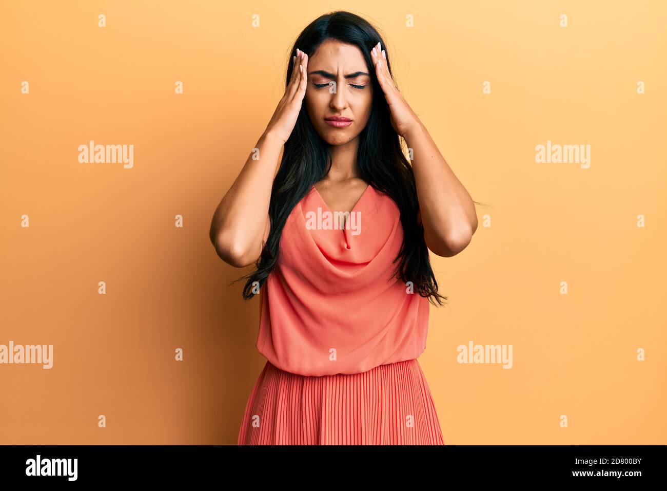 Beautiful hispanic woman wearing summer dress suffering from headache ...
