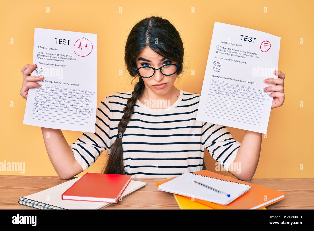 Brunette teenager girl showing failed and passed exam skeptic and ...