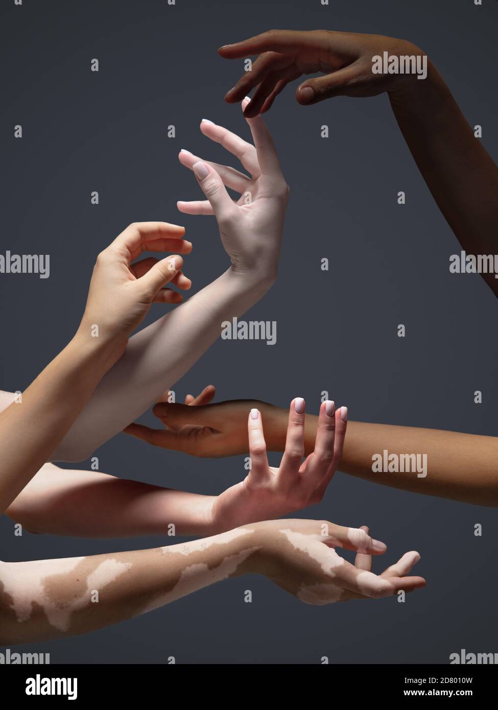 Common goal. Hands of different people in touch isolated on grey studio ...