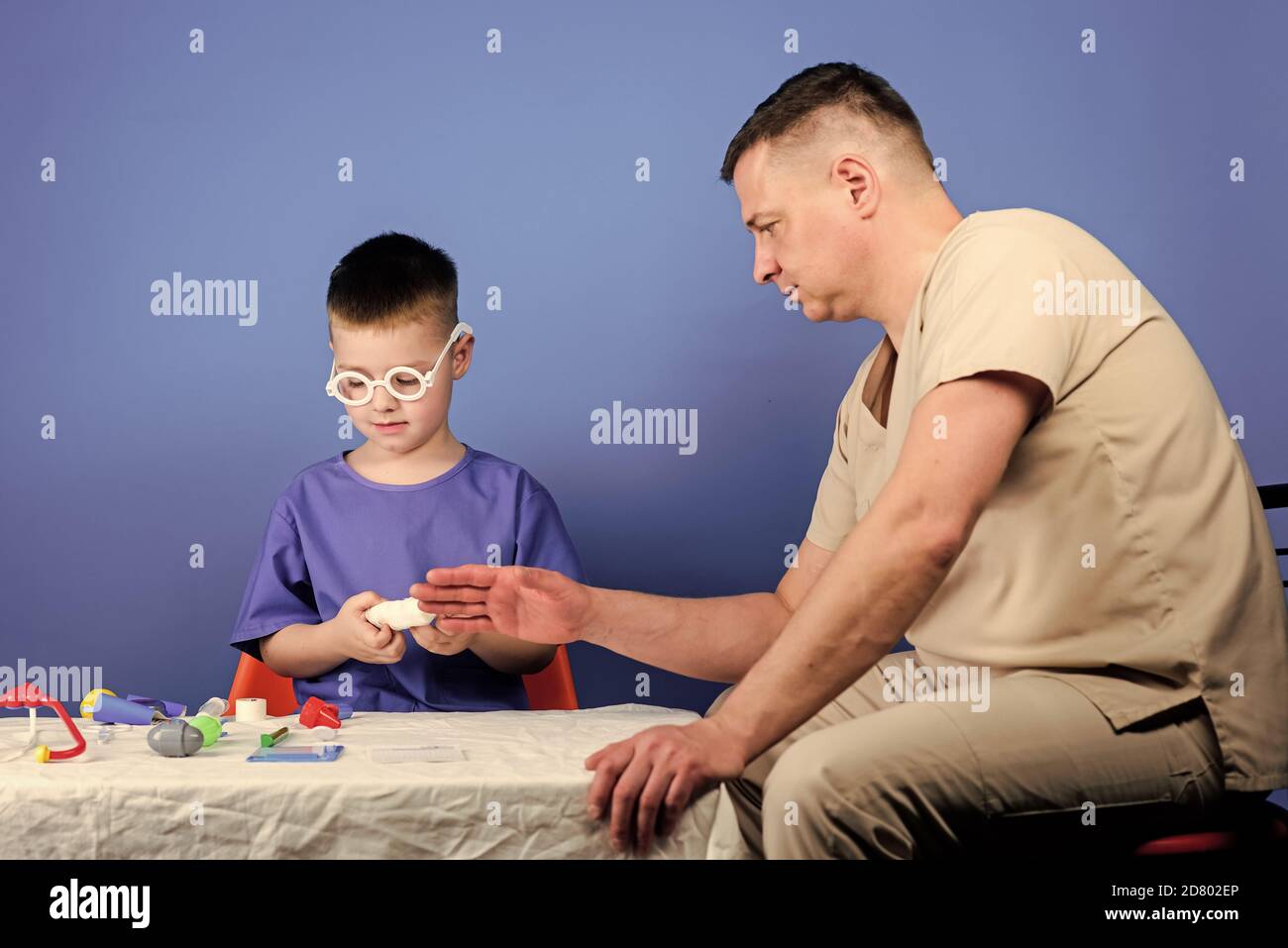 Medicine concept. Kid little doctor sit table medical tools. Illness ...
