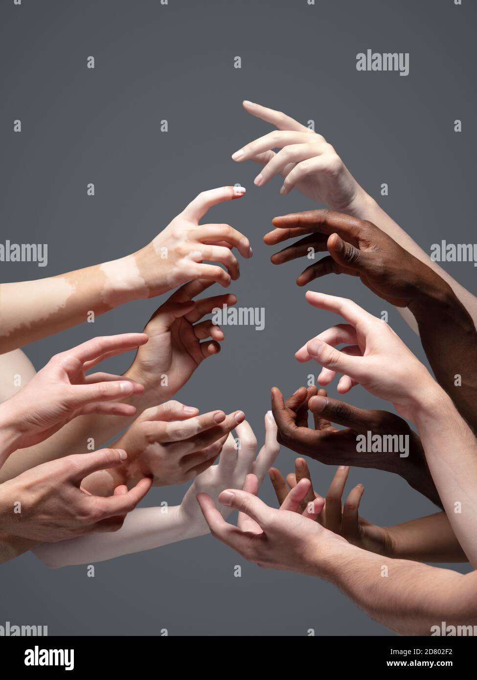Humanity. Hands of different people in touch isolated on grey studio ...