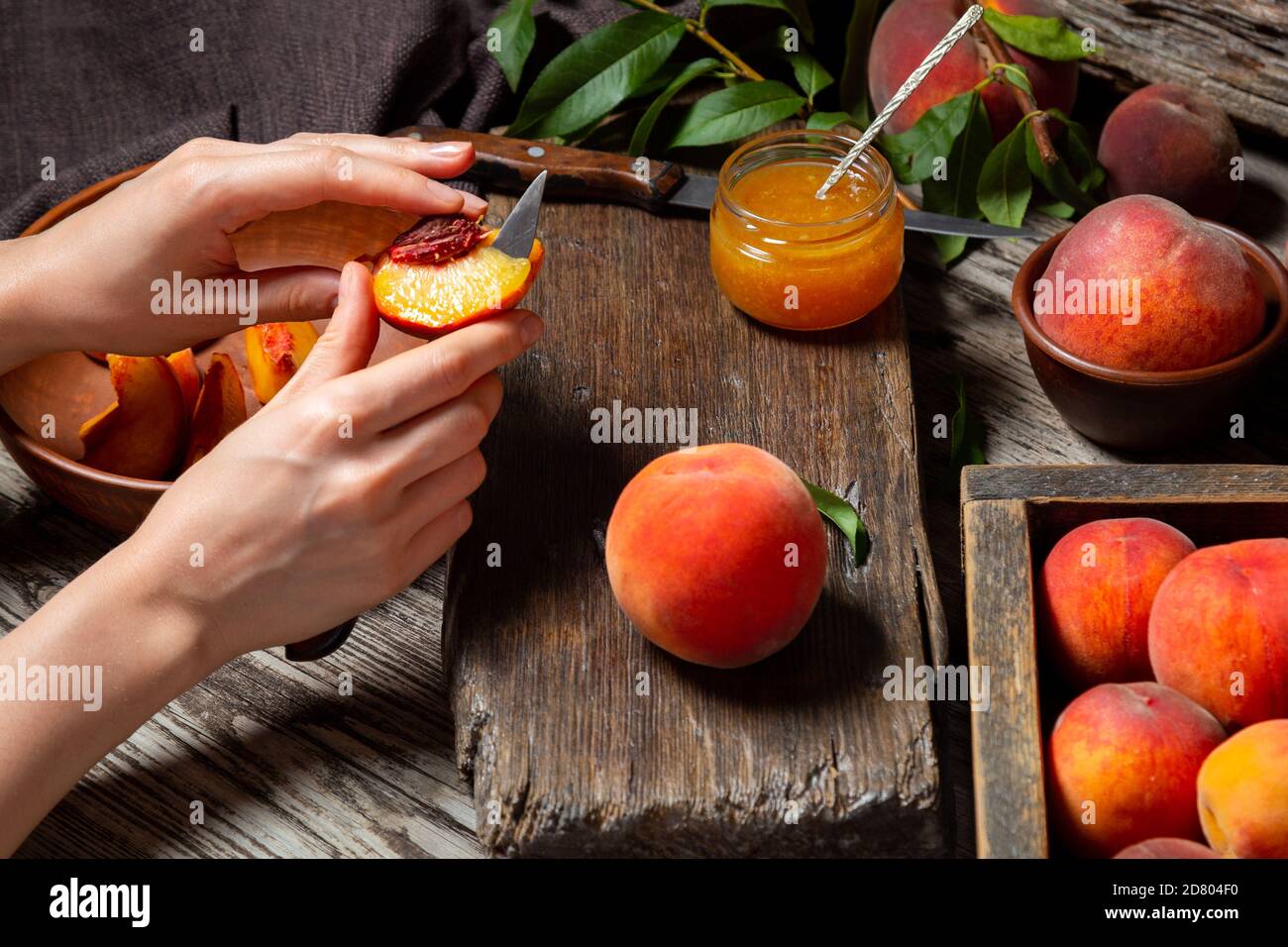 Woman hands cuts peaches for making recipe for jam, dessert, juice on ...