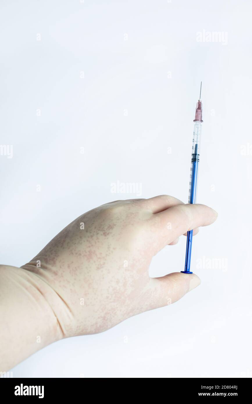 In the hand of rubber gloves hold a syringe Stock Photo - Alamy