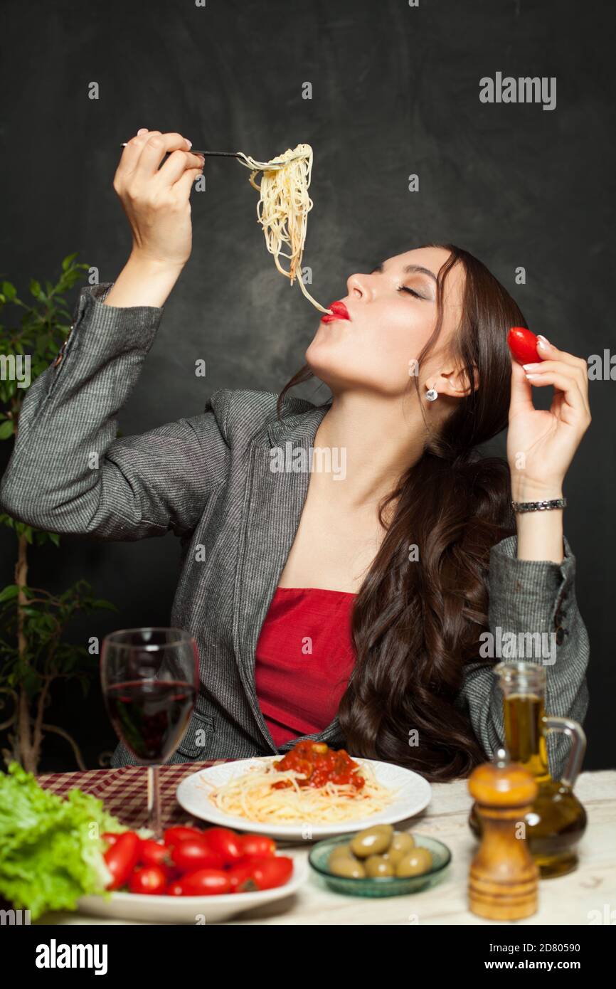 Pretty woman eating italian pasta spaghetti in restaurant Stock Photo ...