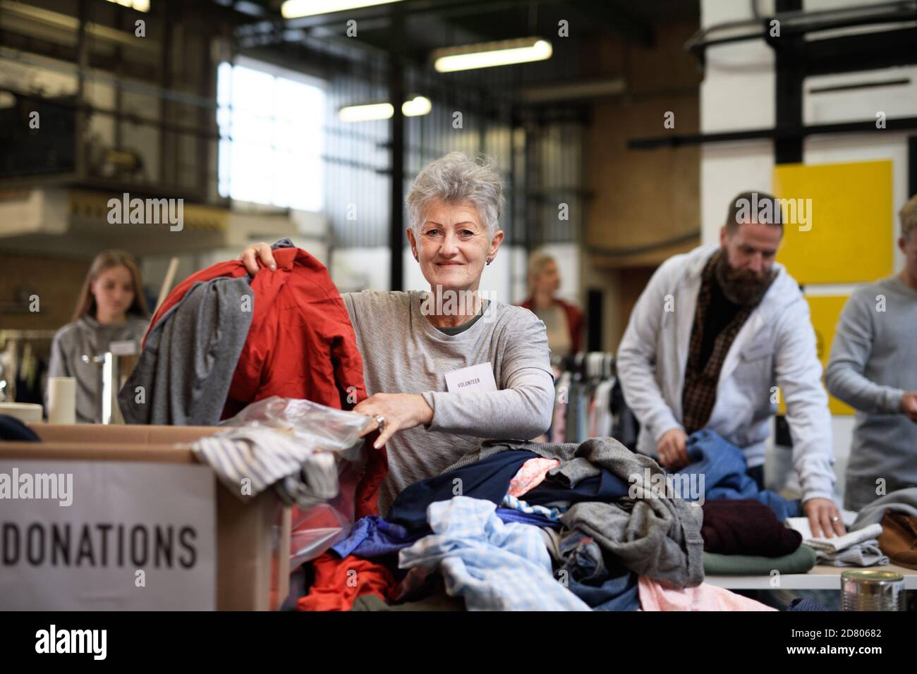 Volunteers sorting out donated clothes in community charity donation ...