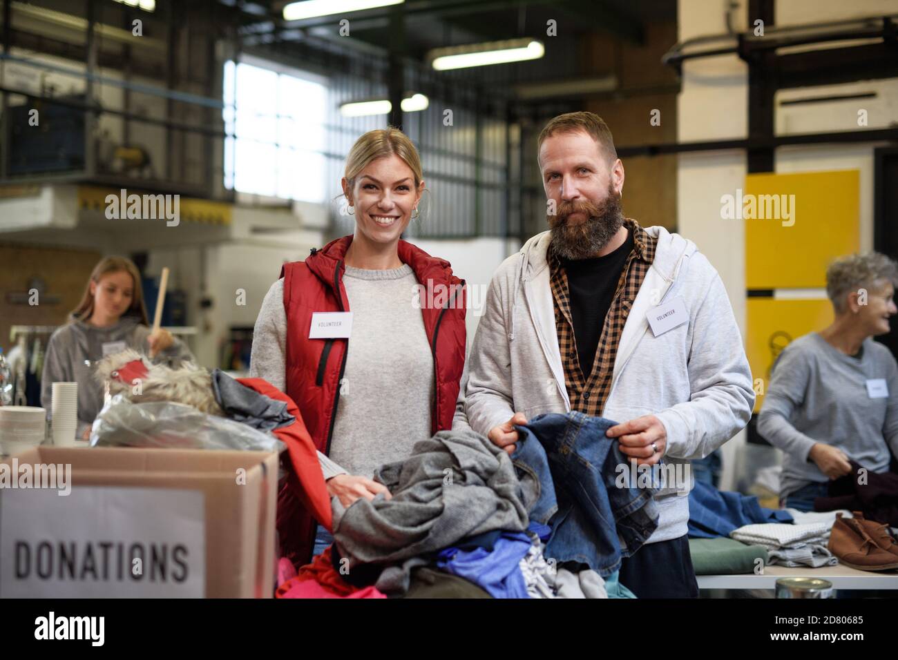Volunteers sorting out donated clothes in community charity donation ...