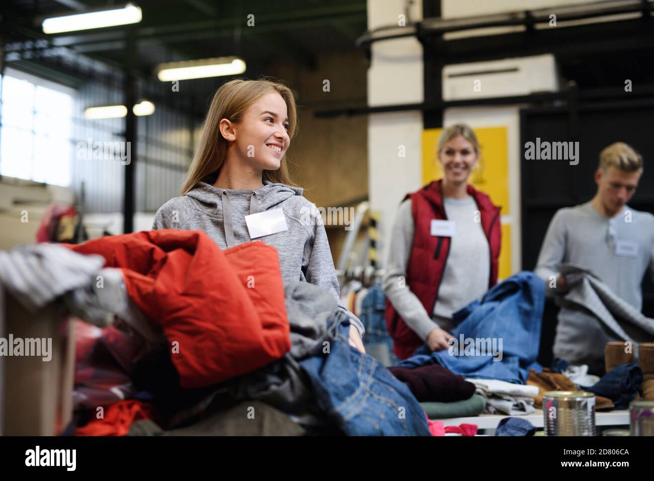 Volunteers sorting out donated clothes in community charity donation ...