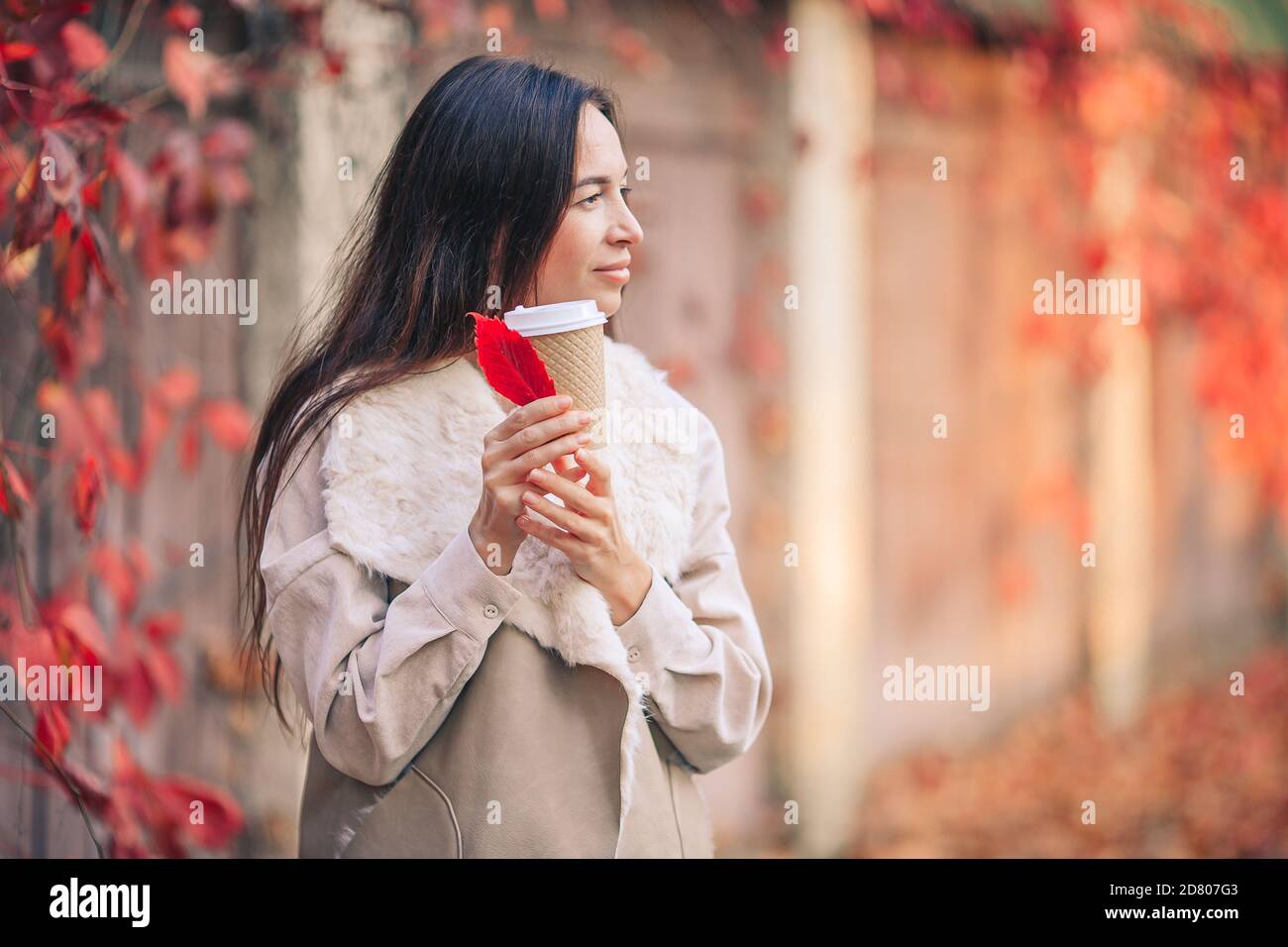Beautiful woman drinking coffee in autumn park under fall foliage Stock ...
