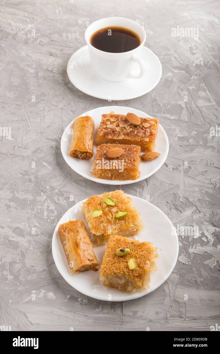traditional arabic sweets (basbus, kunafa, baklava) on white plate and ...