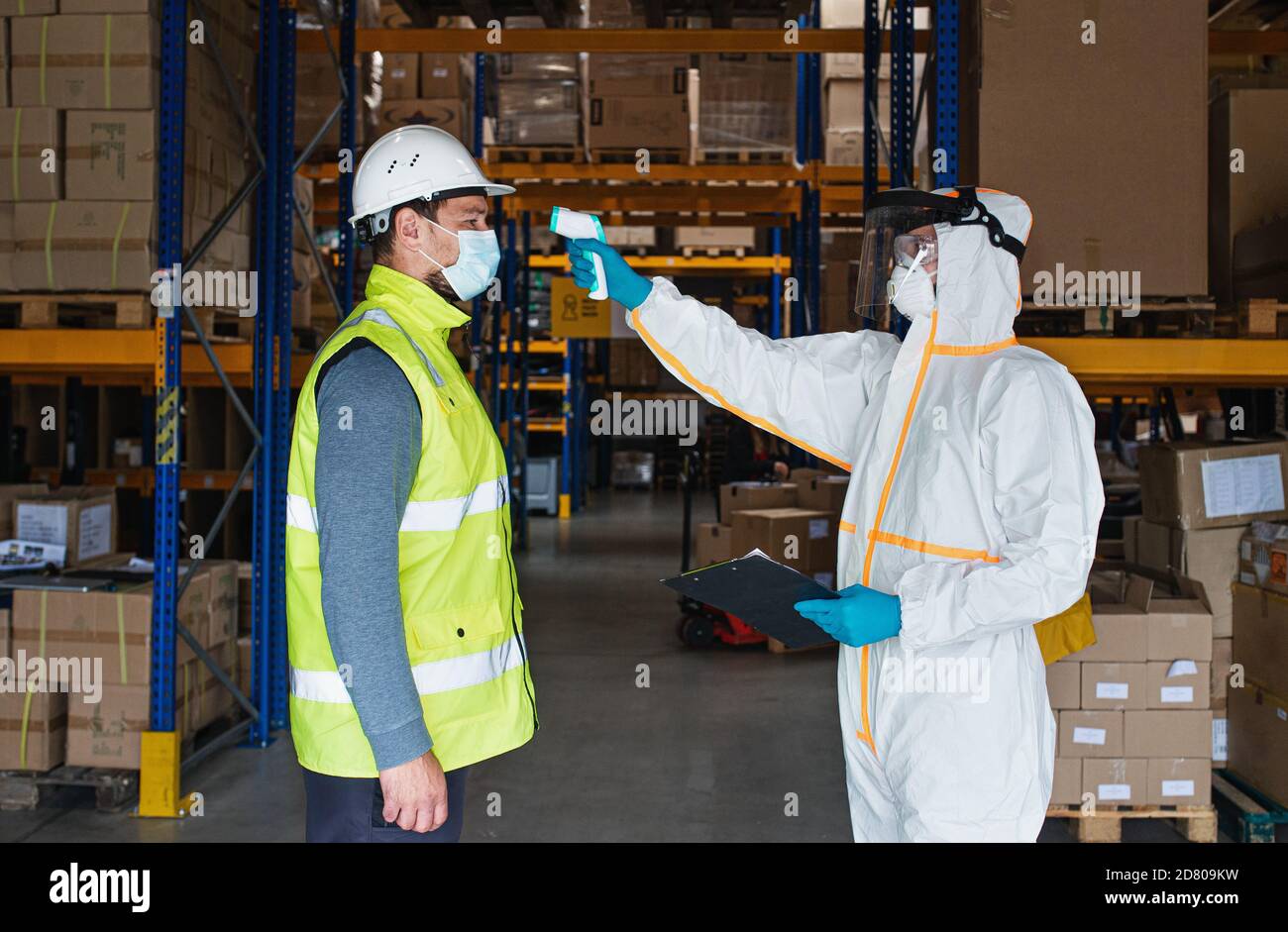 Workers with face mask and suit in warehouse, coronavirus and ...