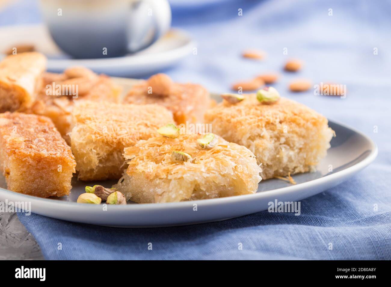 traditional arabic sweets (basbus, kunafa, baklava) and a cup of coffee ...