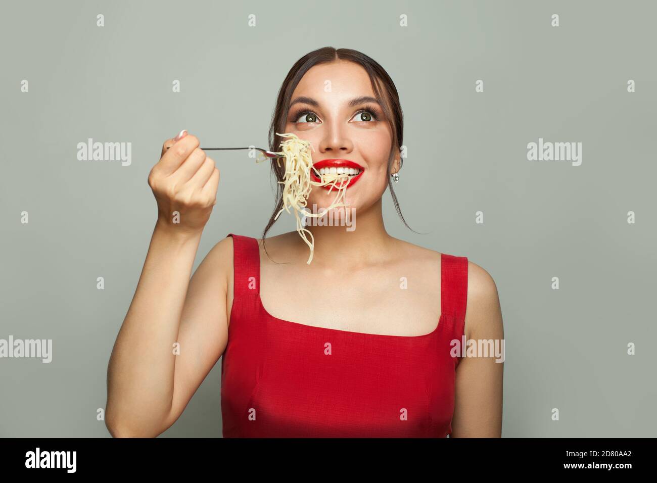 Young perfect woman eating italian pasta spaghetti on white background ...
