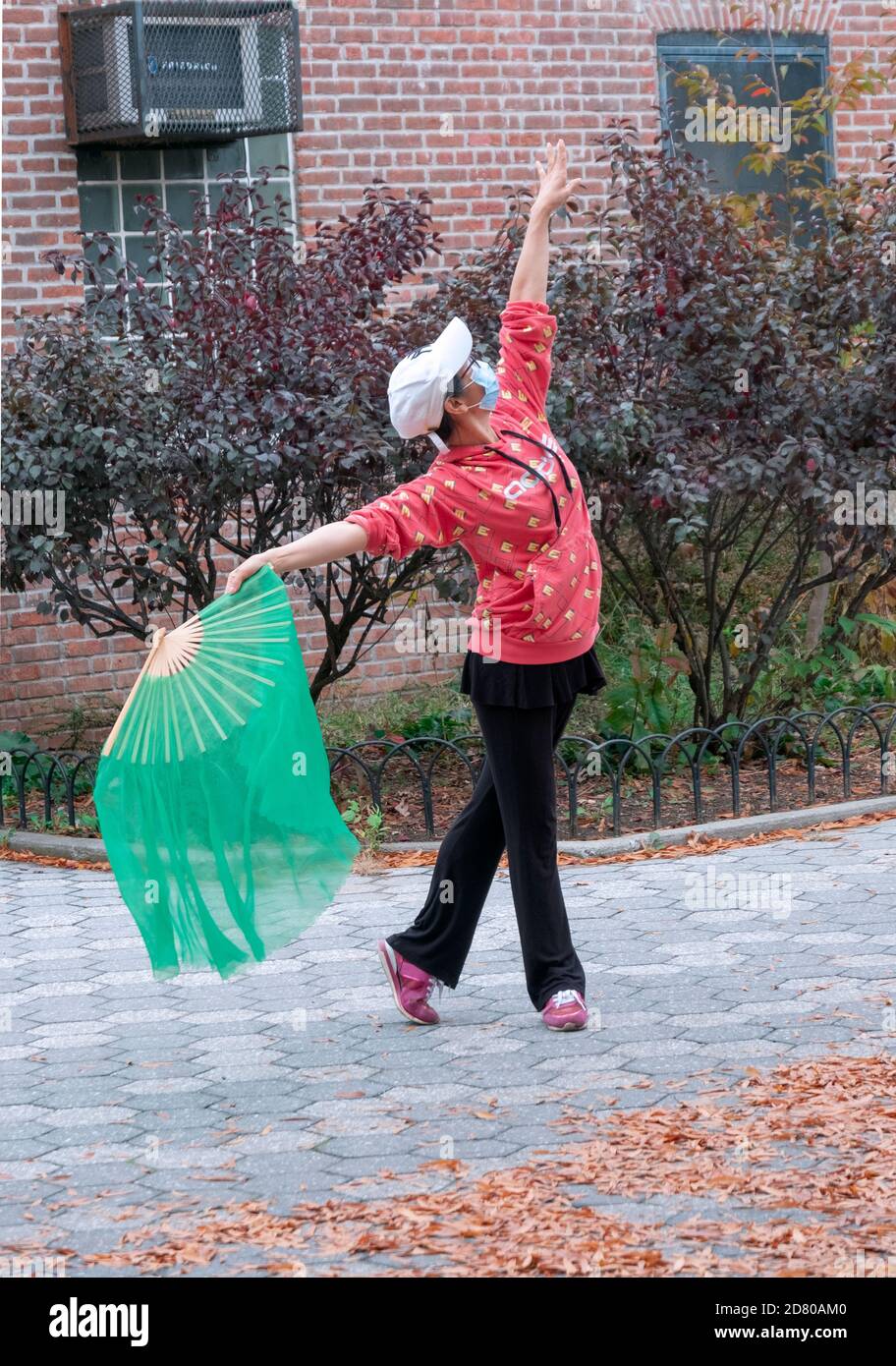 An elegant graceful dancere dancing with a fan that has colorful fabric ...