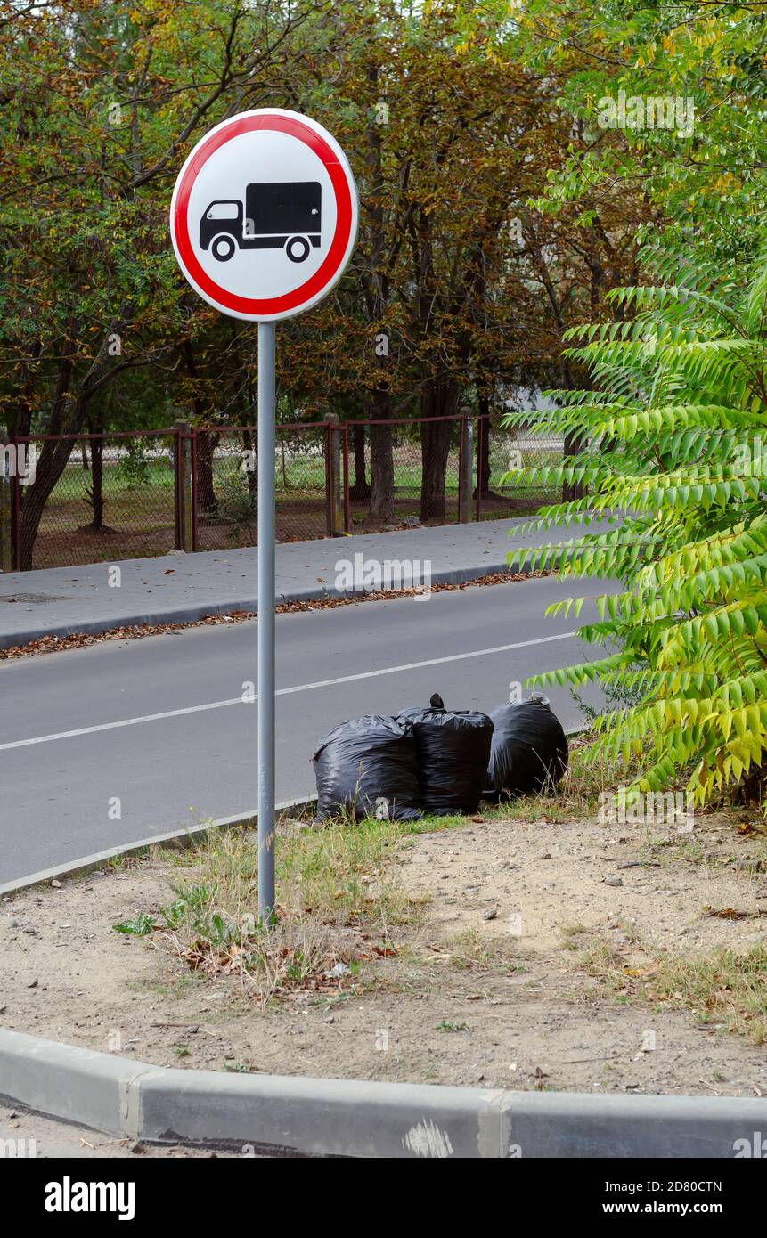 Three full black garbage bags on the side of road sign. Road sign ...