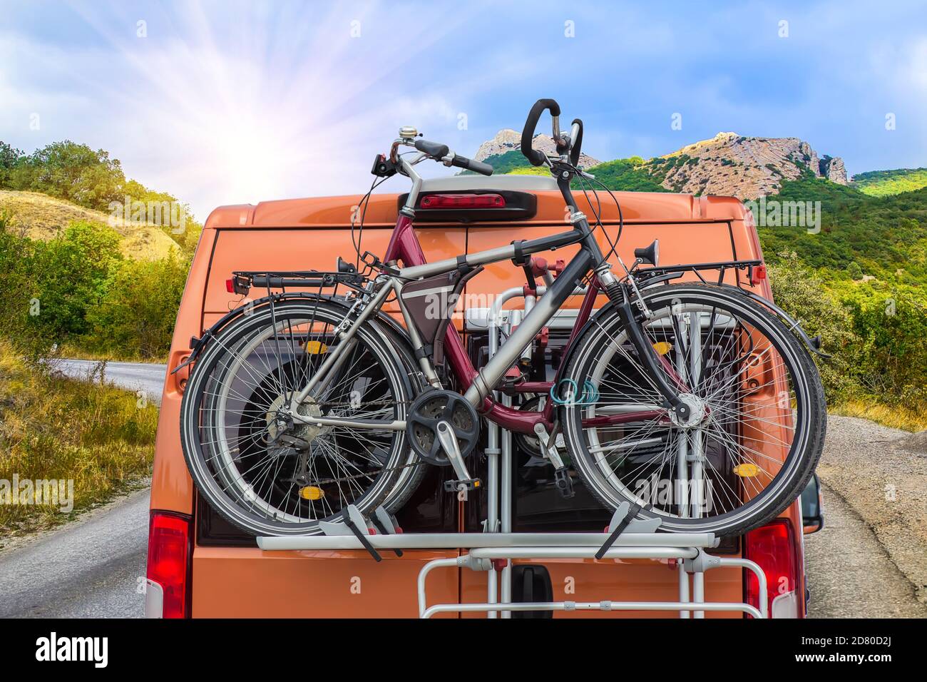 bicycles on the trunk of a minivan moving on a mountain winding road ...