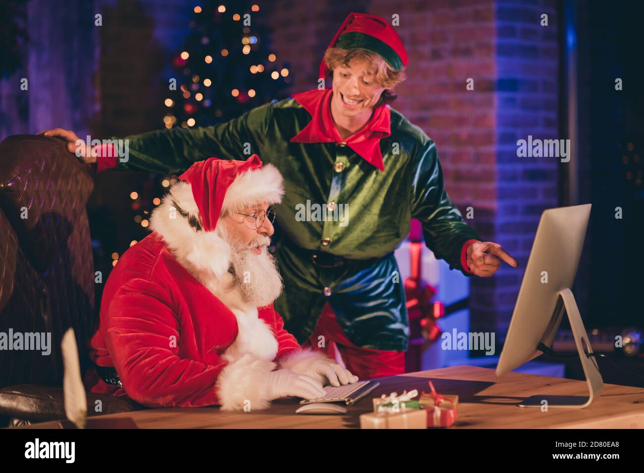 Photo portrait of elf pointing finger at desktop screen while santa ...