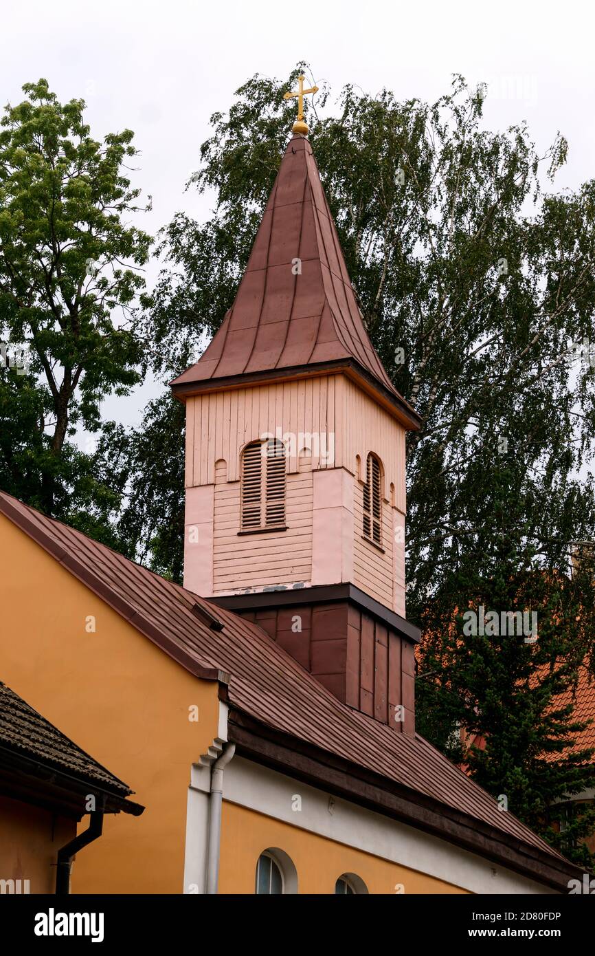 Church tower with a cross on the street of the small town of Cesis in ...