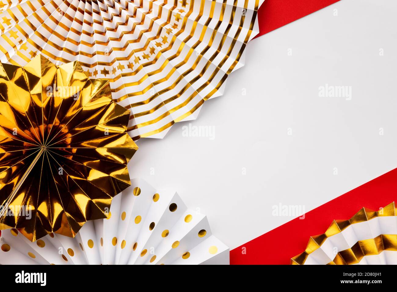 White and golden paper fans on red background. Party, decorations ...