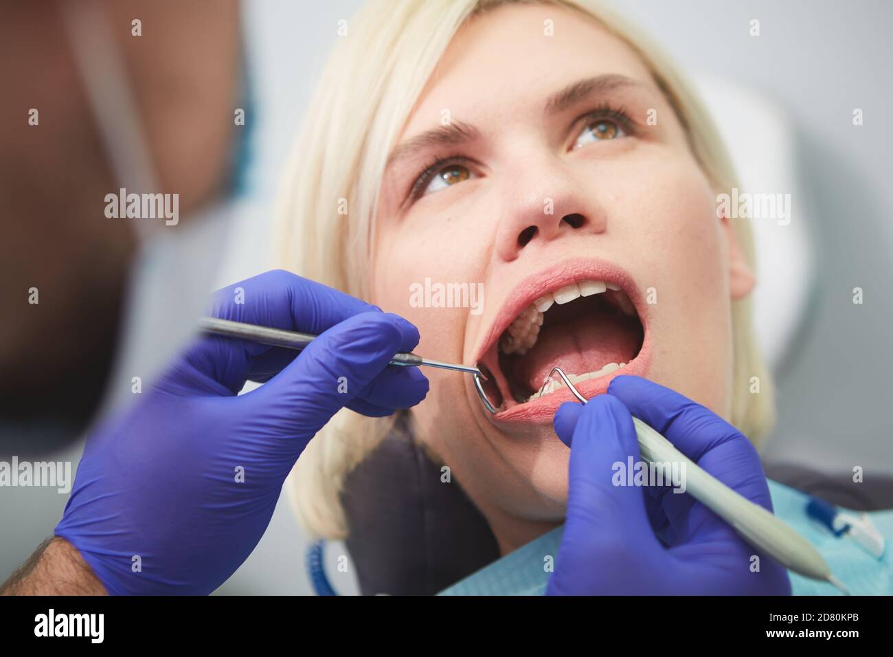 Young smiling woman with beautifiul teeth, having a dental inspection ...
