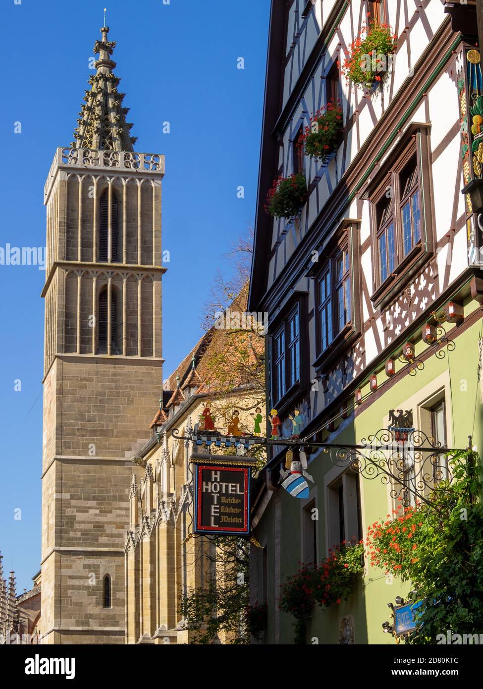 A tower of Rothenburg ob der Tauber St. Jakob Church by a timber-framed ...