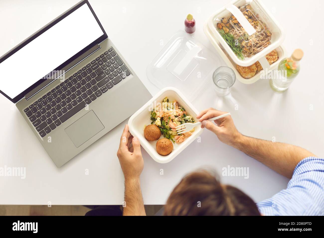 Busy man having lunch break at office desk with laptop computer with ...