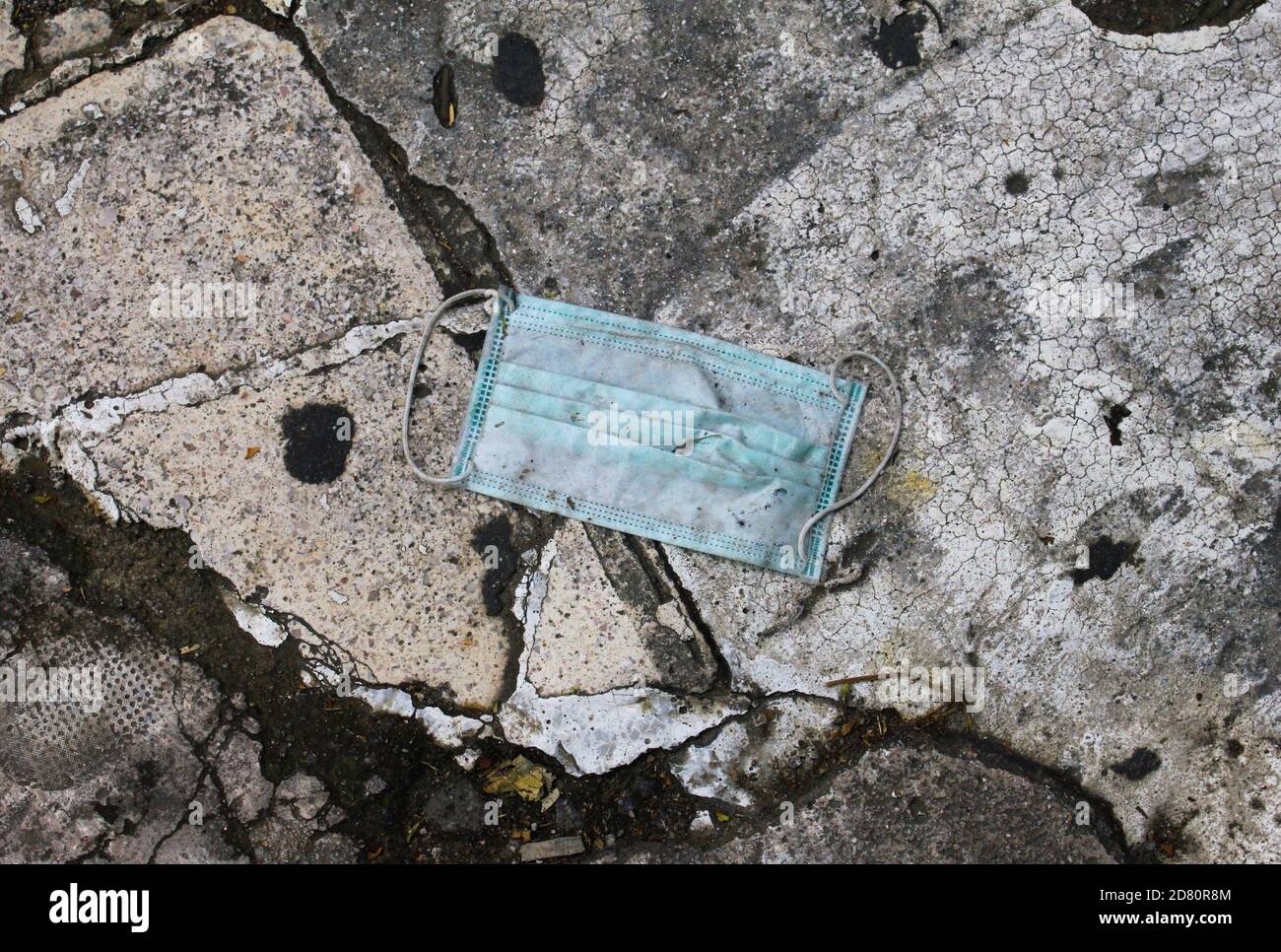 Surgical face mask thrown on the ground Stock Photo - Alamy