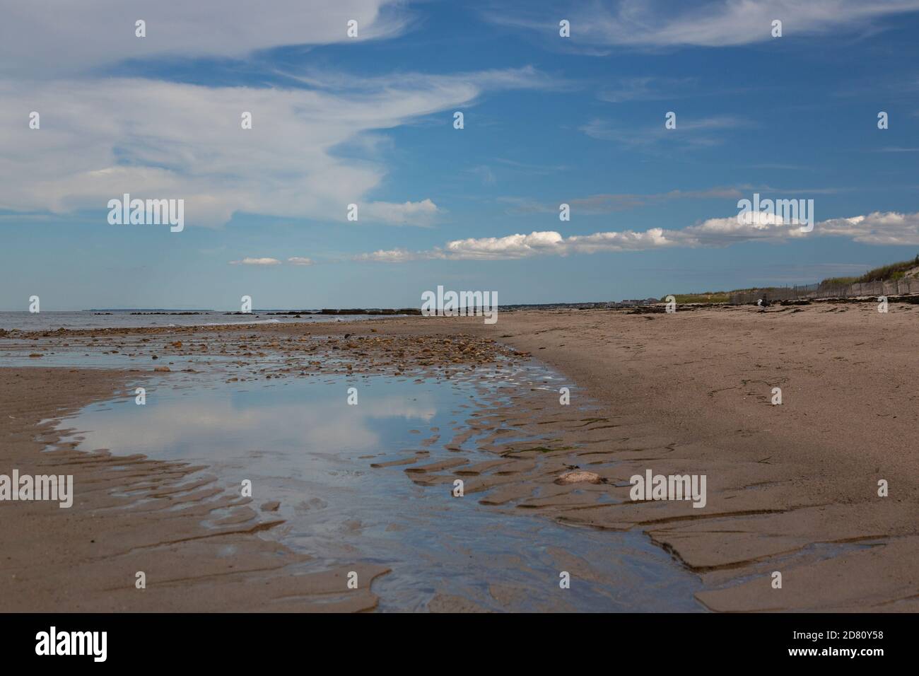 Beautiful reflections of sky along a beach with sand dunes in ...