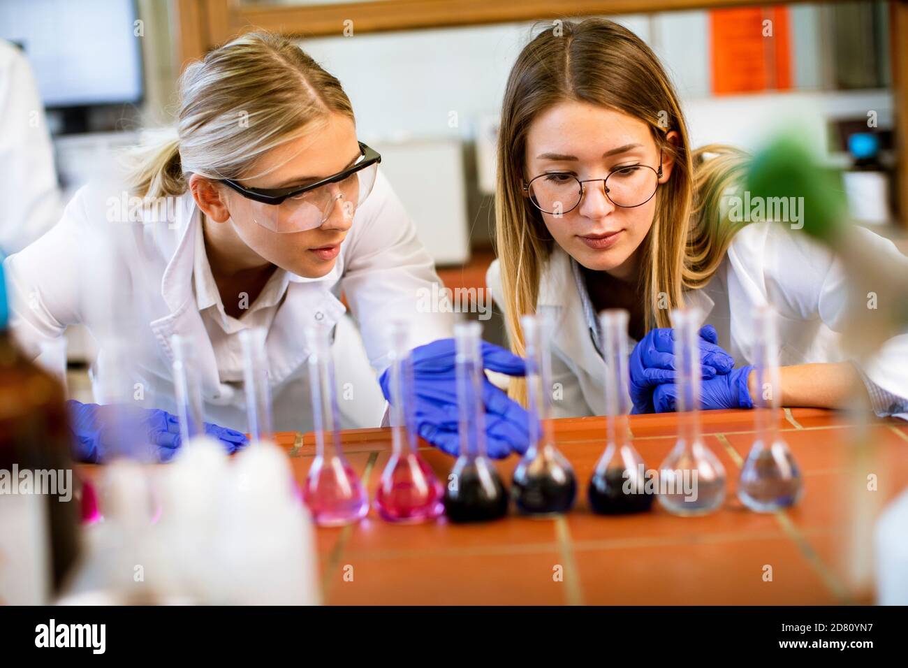 Cute female researchers in white lab coat working in the laboratory ...