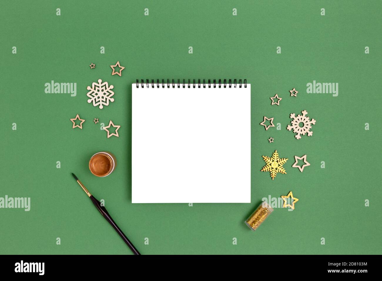 Clean notepad mockup with wooden New Years decoration and golden paint ...