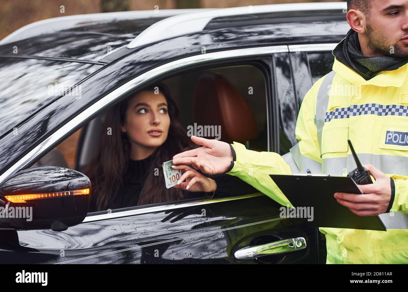 Male police officer in green uniform taking bribe from vehile driver on ...