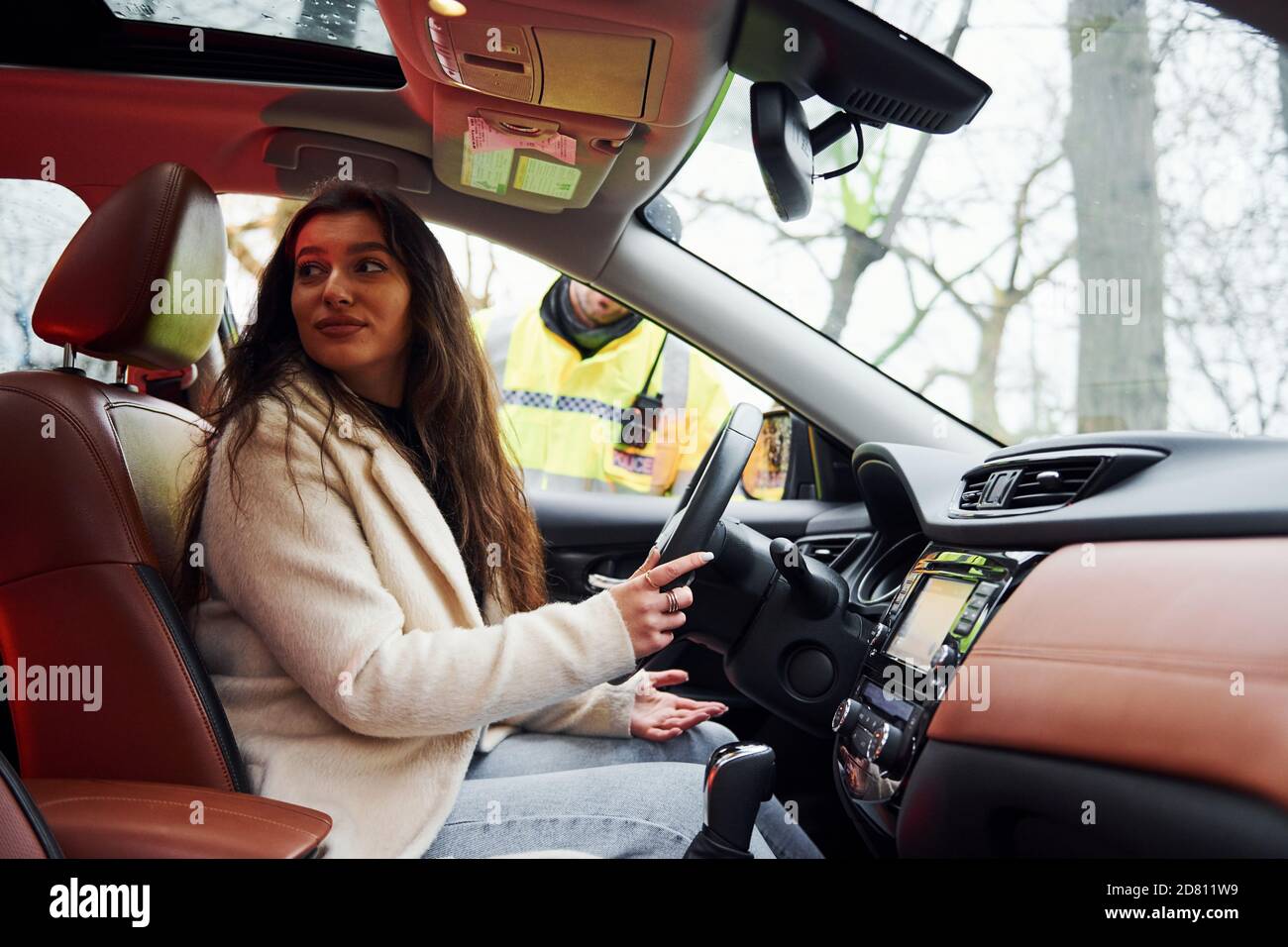 Male police officer in green uniform checking vehicle on the road Stock ...