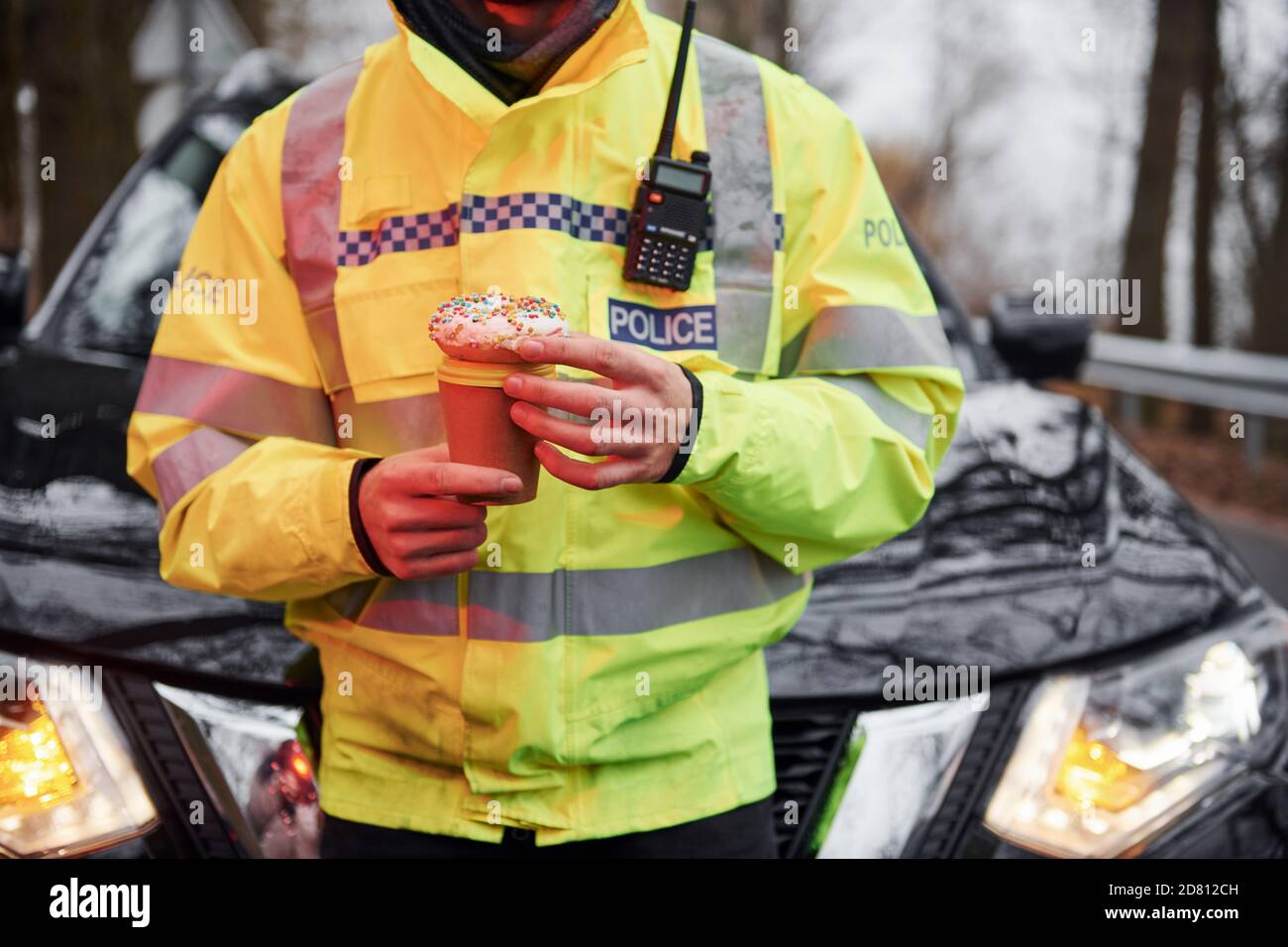 Male police officer in green uniform taking a break with donut on the ...