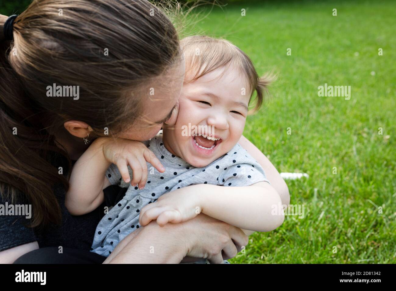 Happy Toddler Daughter Laughs As Mother Snuggles Her Closely Stock ...