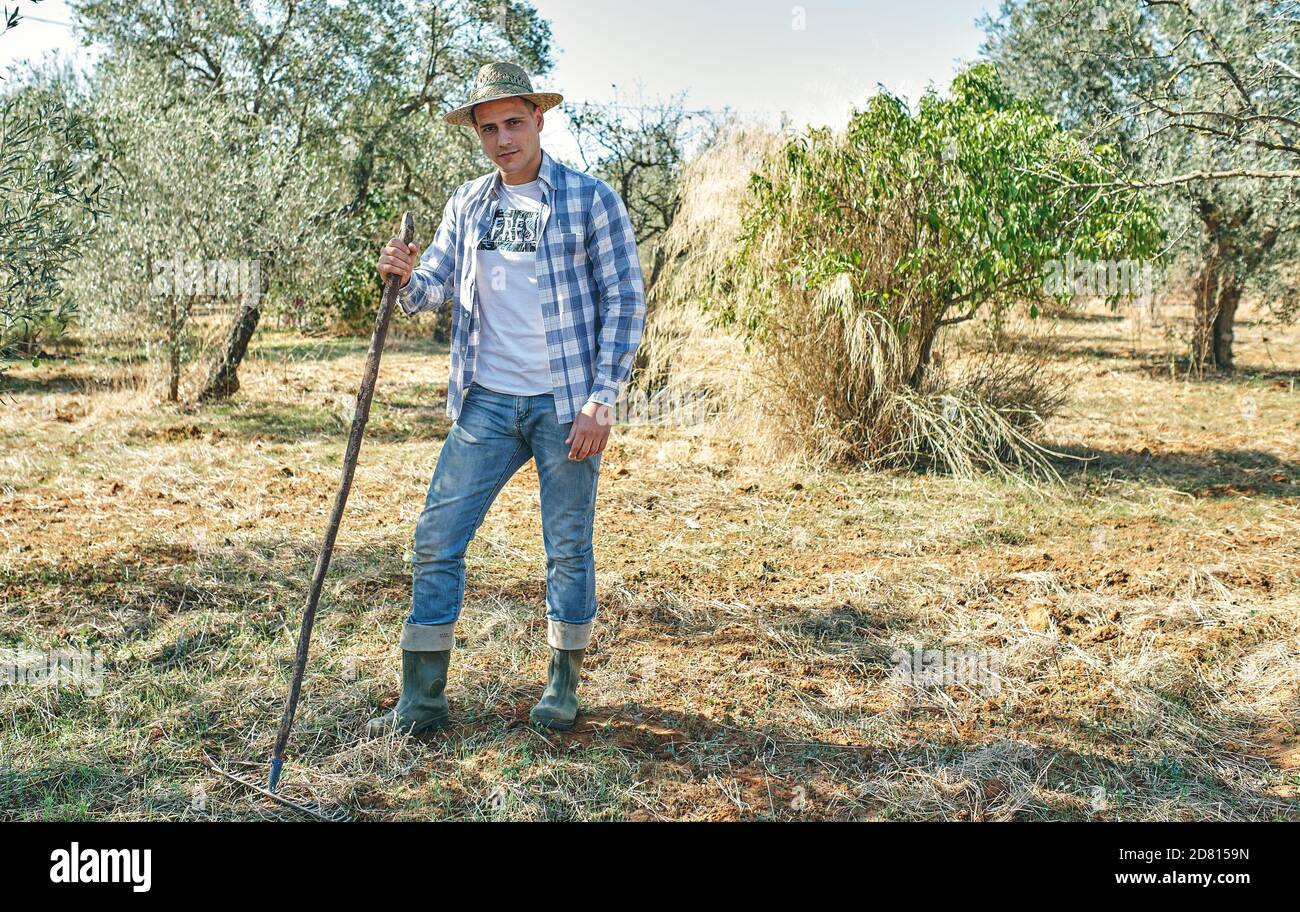 farmer works with his rake to clear his land Stock Photo - Alamy