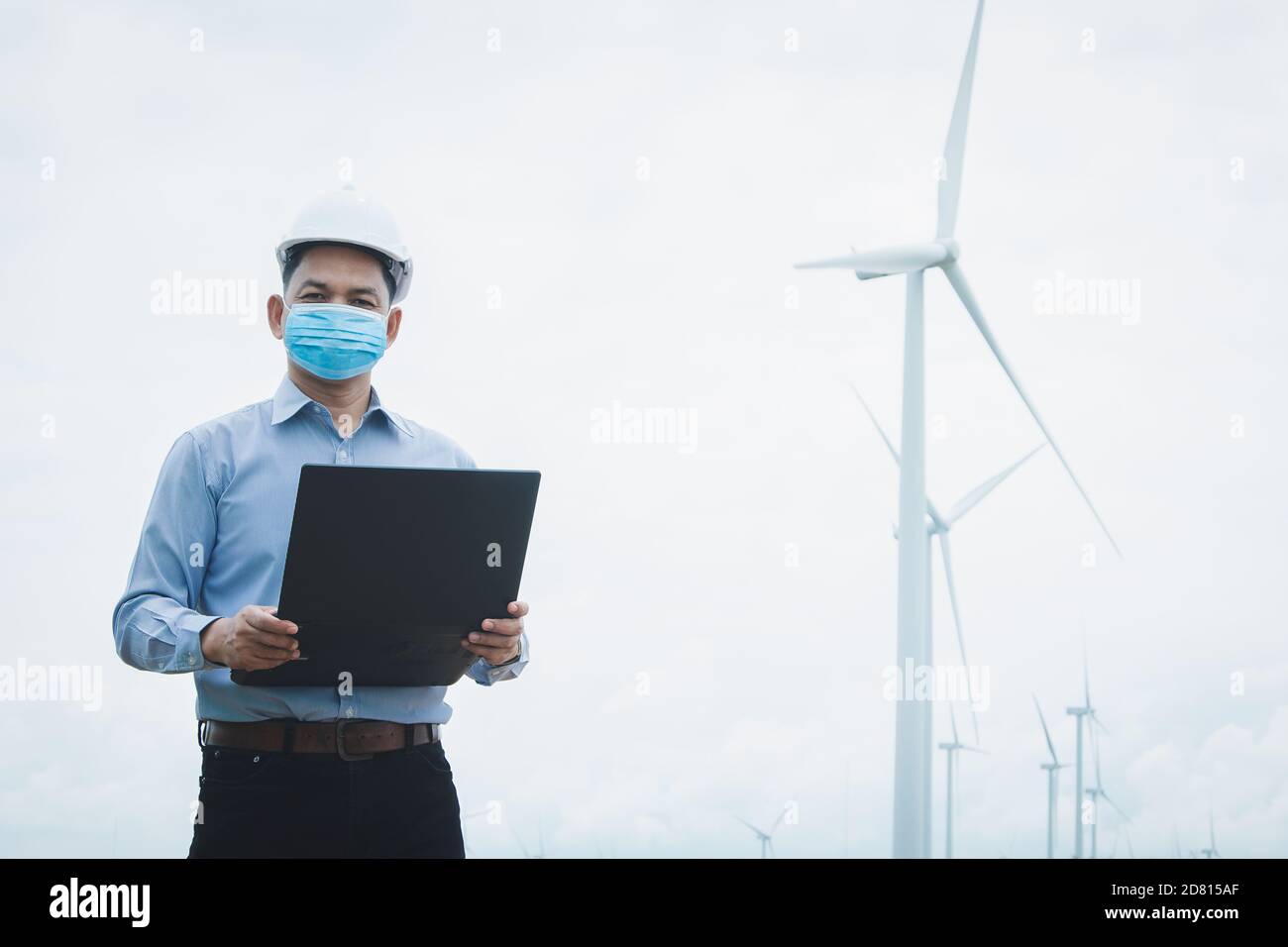 Engineers windmills wearing face mask and working on laptop with the ...