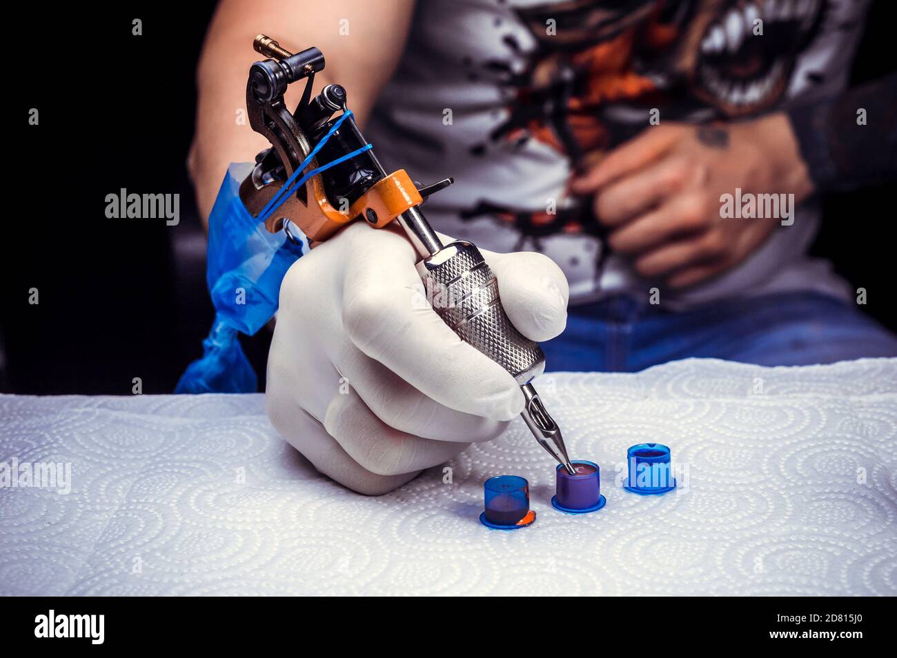 Hand of a professional tattooist and a tattoo machine Stock Photo - Alamy