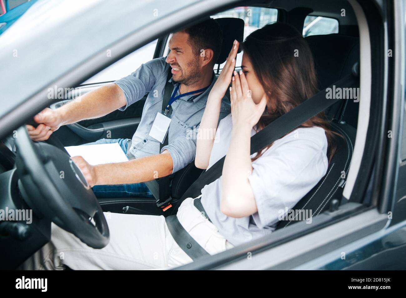 Male driving instructor trying to avoid a collision with another car ...