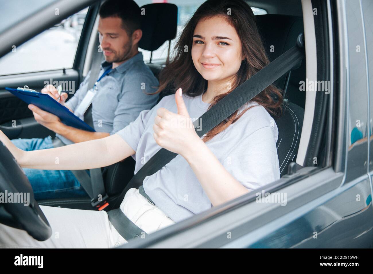 Female student showing thumbs up and smiling. Cheerful young woman ...
