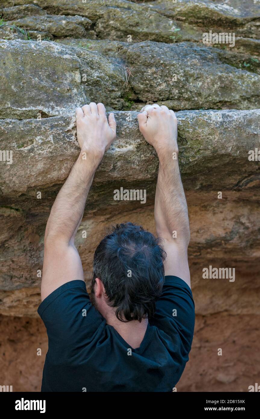Climber trying to climb the rock, with his hands Stock Photo - Alamy