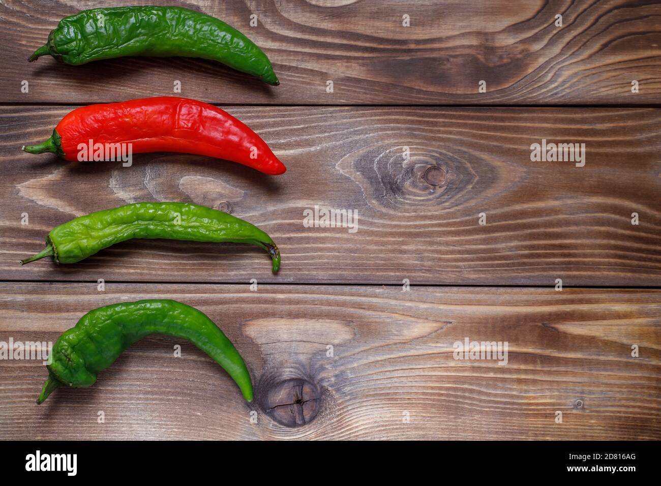 Shriveled stale peppers on a wooden background. Flat layout. Space for ...