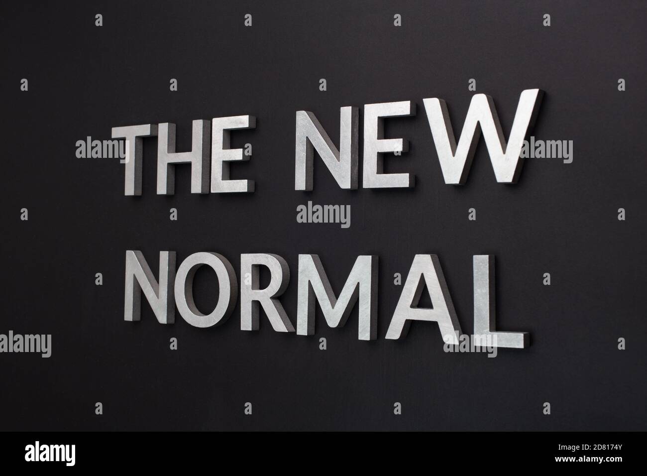 words the new normal on black surface in tilted linear perspective ...