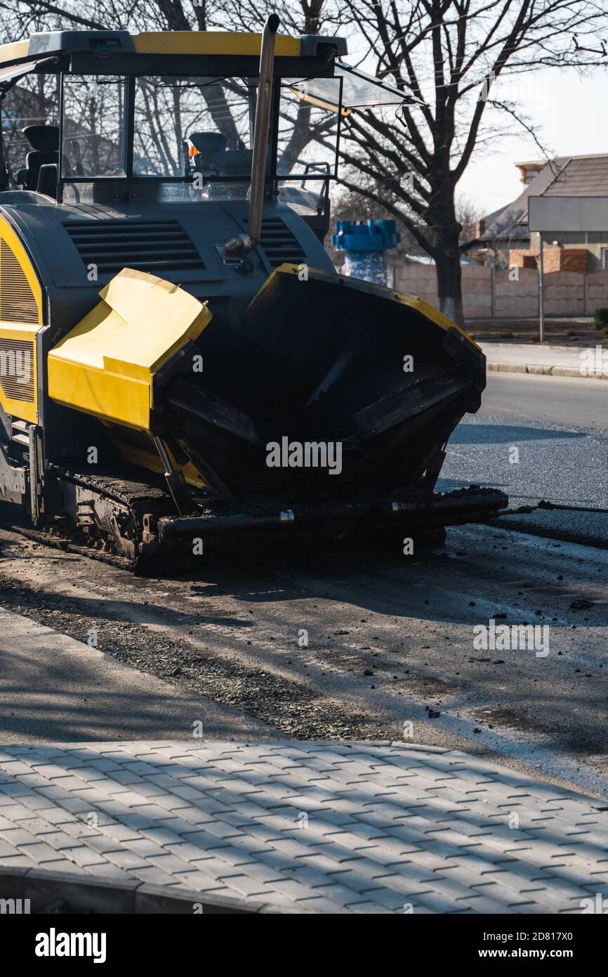 Industrial asphalt paver machine laying fresh asphalt on road ...