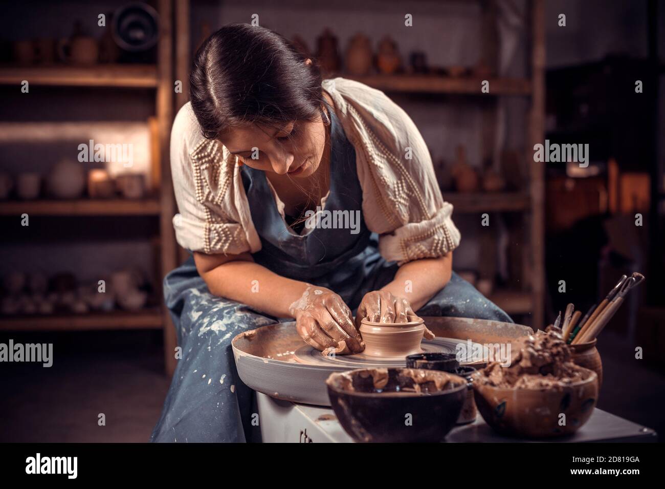 Beautifulpotter master woman at his wheel creating a new masterpiece ...