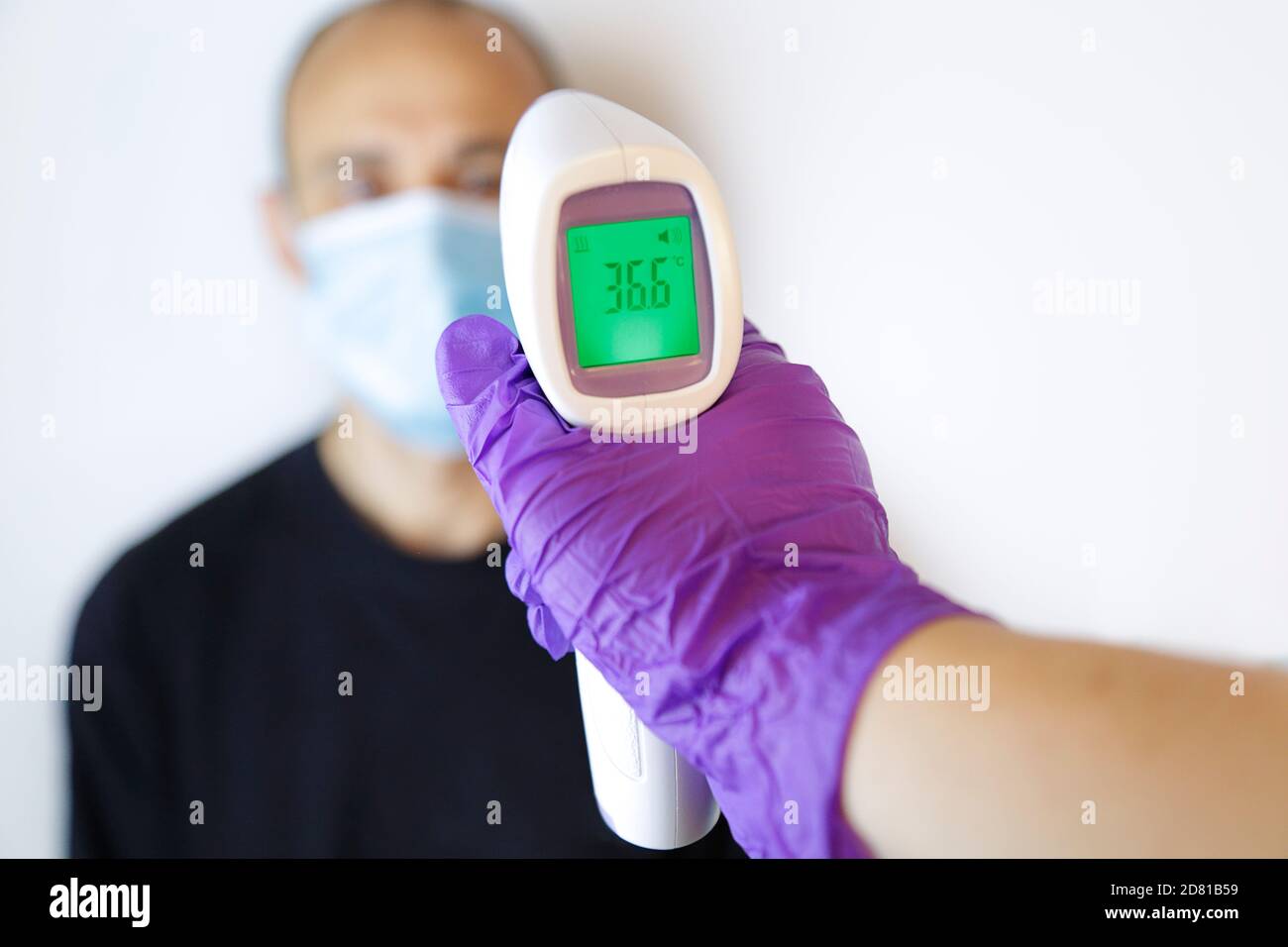 Hand holding a digital thermometer measuring a man temperature Stock ...