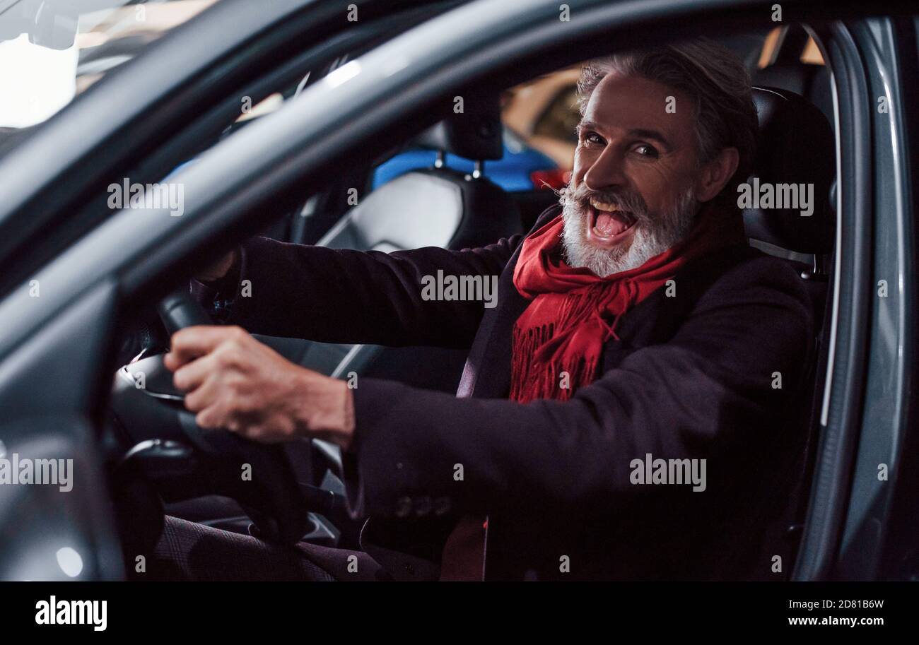 Happy stylish senior man with grey hair and mustache is in the modern ...
