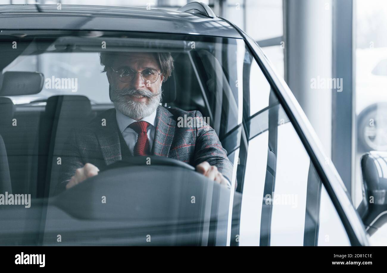 Happy stylish senior man with grey hair and mustache is in the modern ...